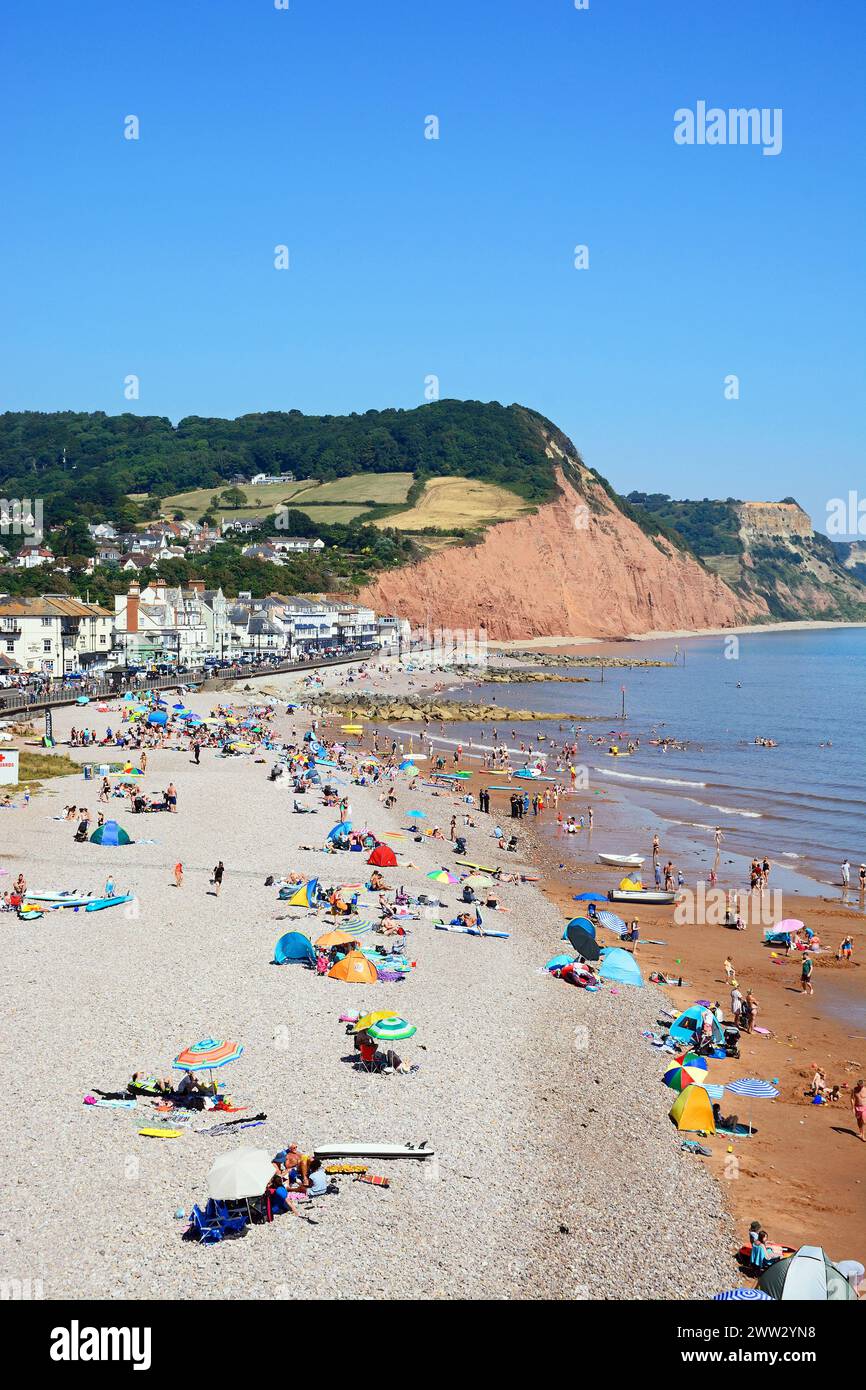 Tourists relaxing on the beach with views towards town buildings and ...
