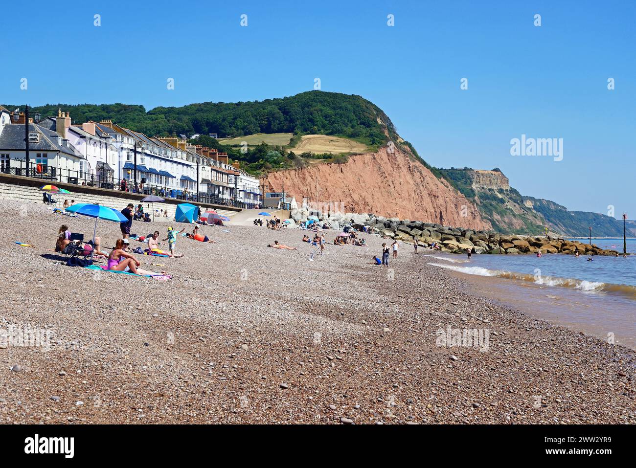 Tourists relaxing on the beach with views towards town buildings and ...