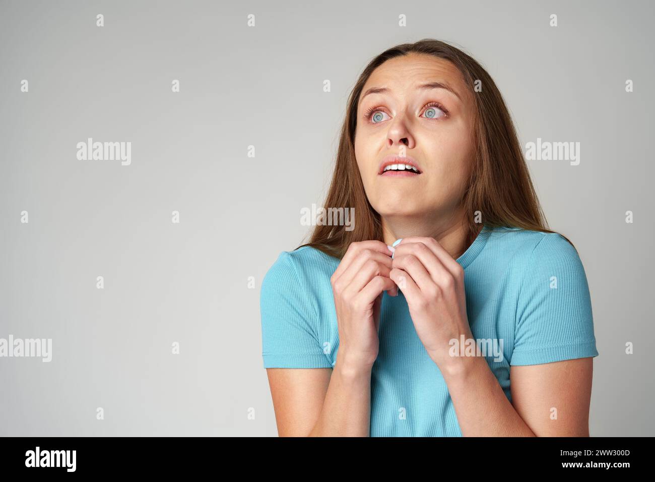 Emotional frightened young woman on gray background Stock Photo - Alamy
