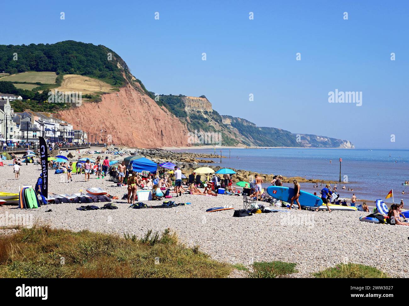 Tourists relaxing on the beach with views towards town buildings and ...