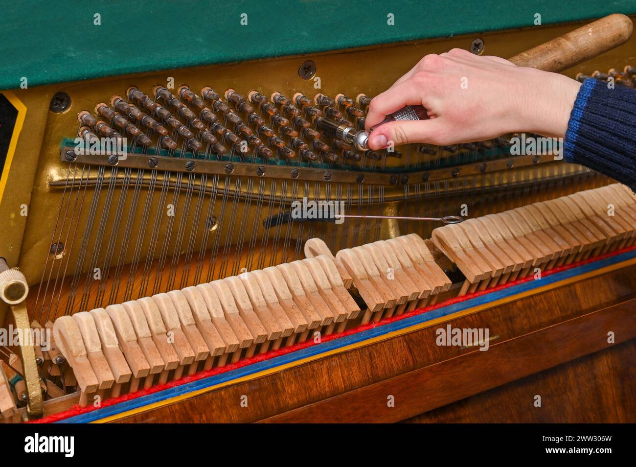 The tuner has a piano tuning instrument in his hand Stock Photo - Alamy