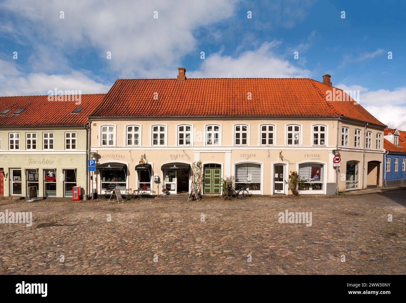 Cobblestoned square Torvet with various shops in old town of Mariager ...