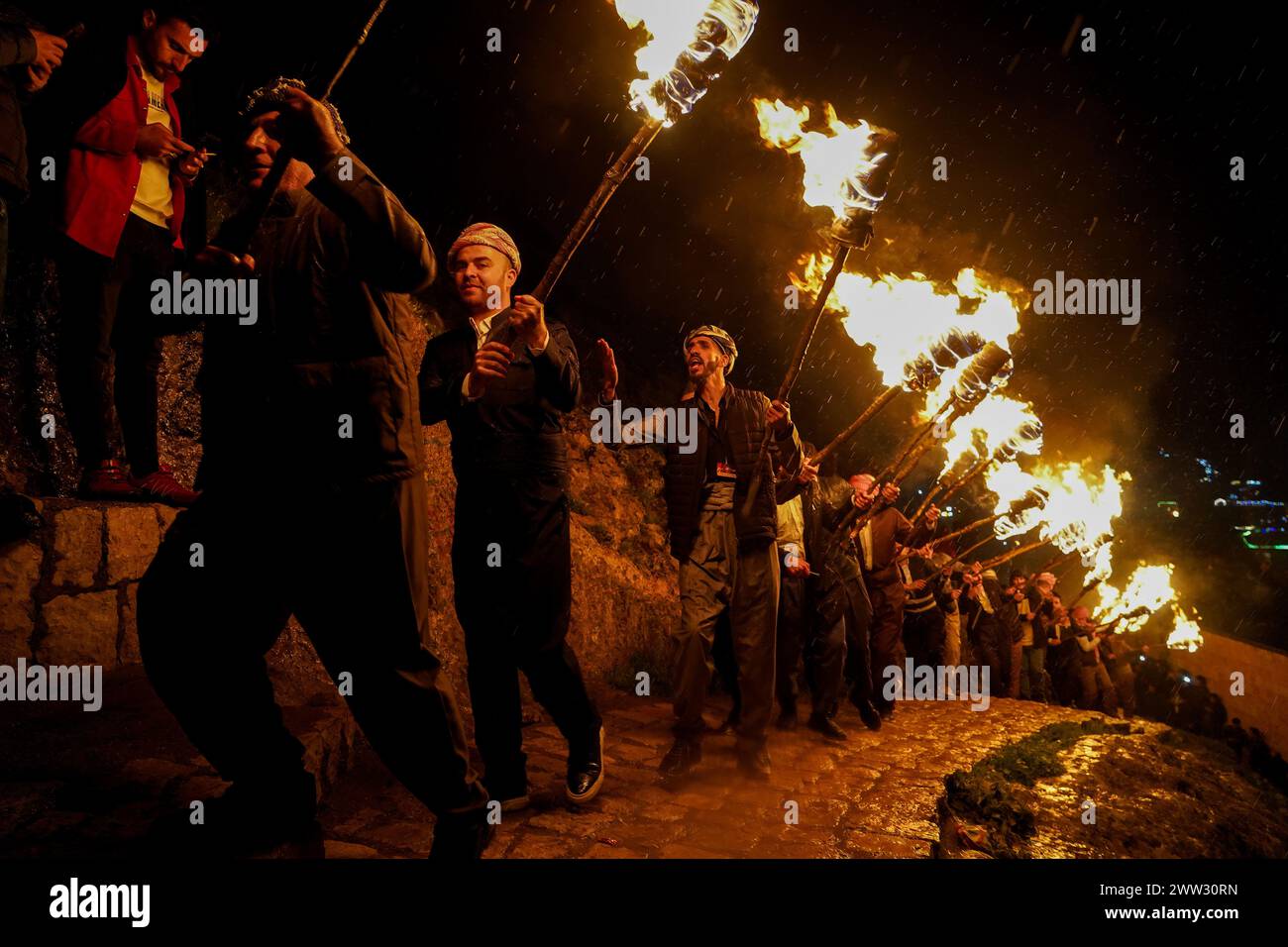 Akre, Iraq. 20th Mar, 2024. Iraqi Kurds carry fire torches as they ...