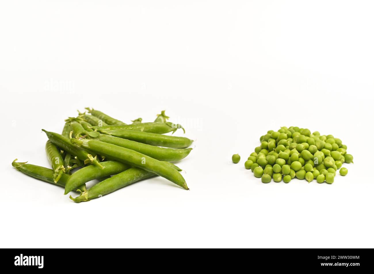 pods of fresh peas and a bunch of peeled peas on a white background ...