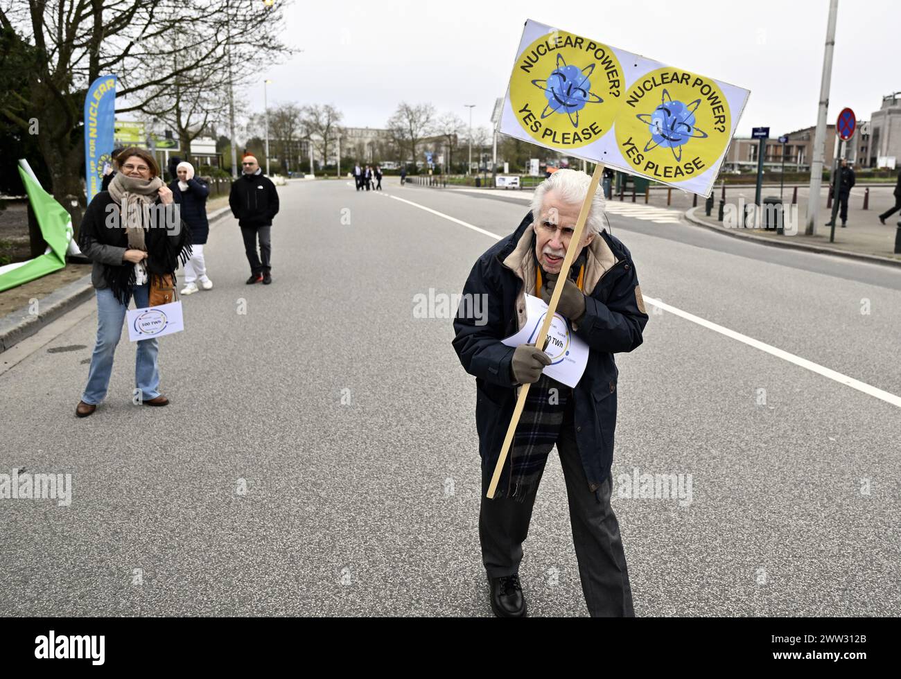 A demonstrators holds a protest sign reading 'Nuclear power, Yes please ...