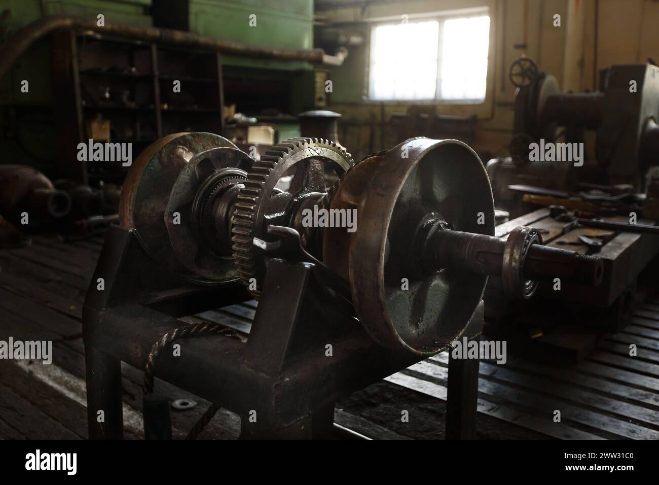 Vintage machinery in old factory, industrial gears on workbench ...