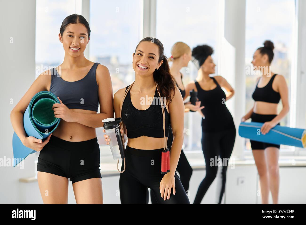 focus on happy diverse female friends in active wear smiling at camera ...