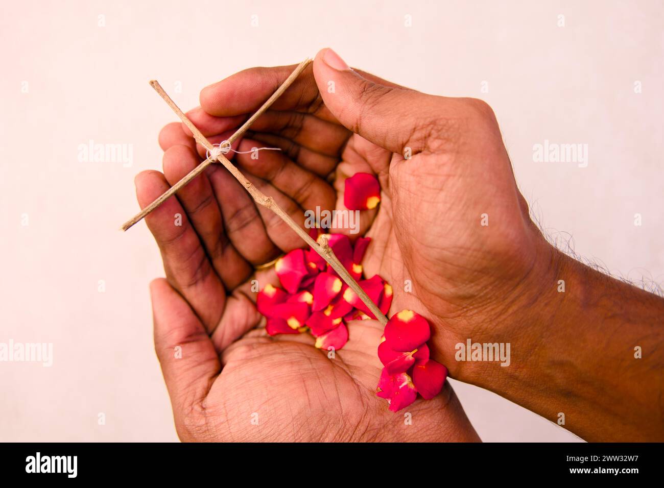 A close-up photo of gentle hands cradling a simple wooden cross ...