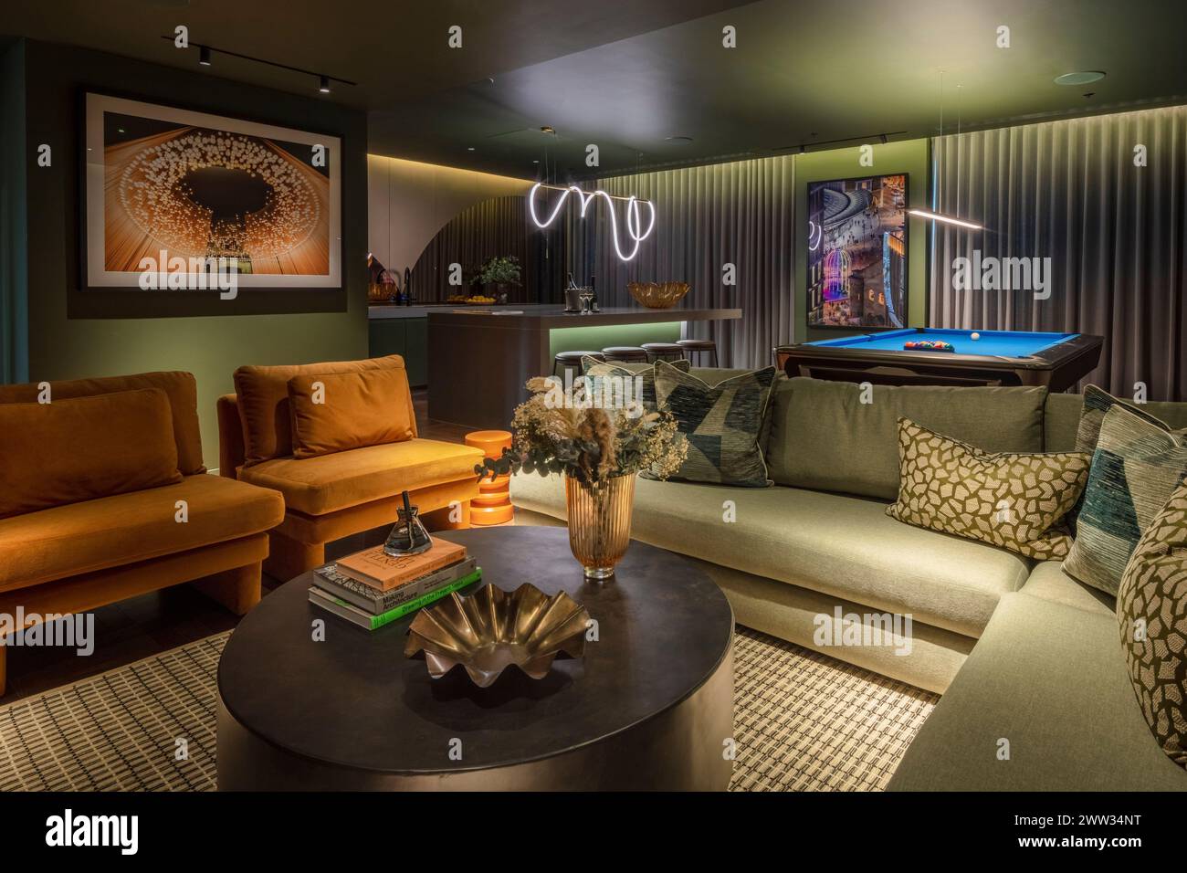 Communal living space with kitchen bar and sculptural lighting. Author ...