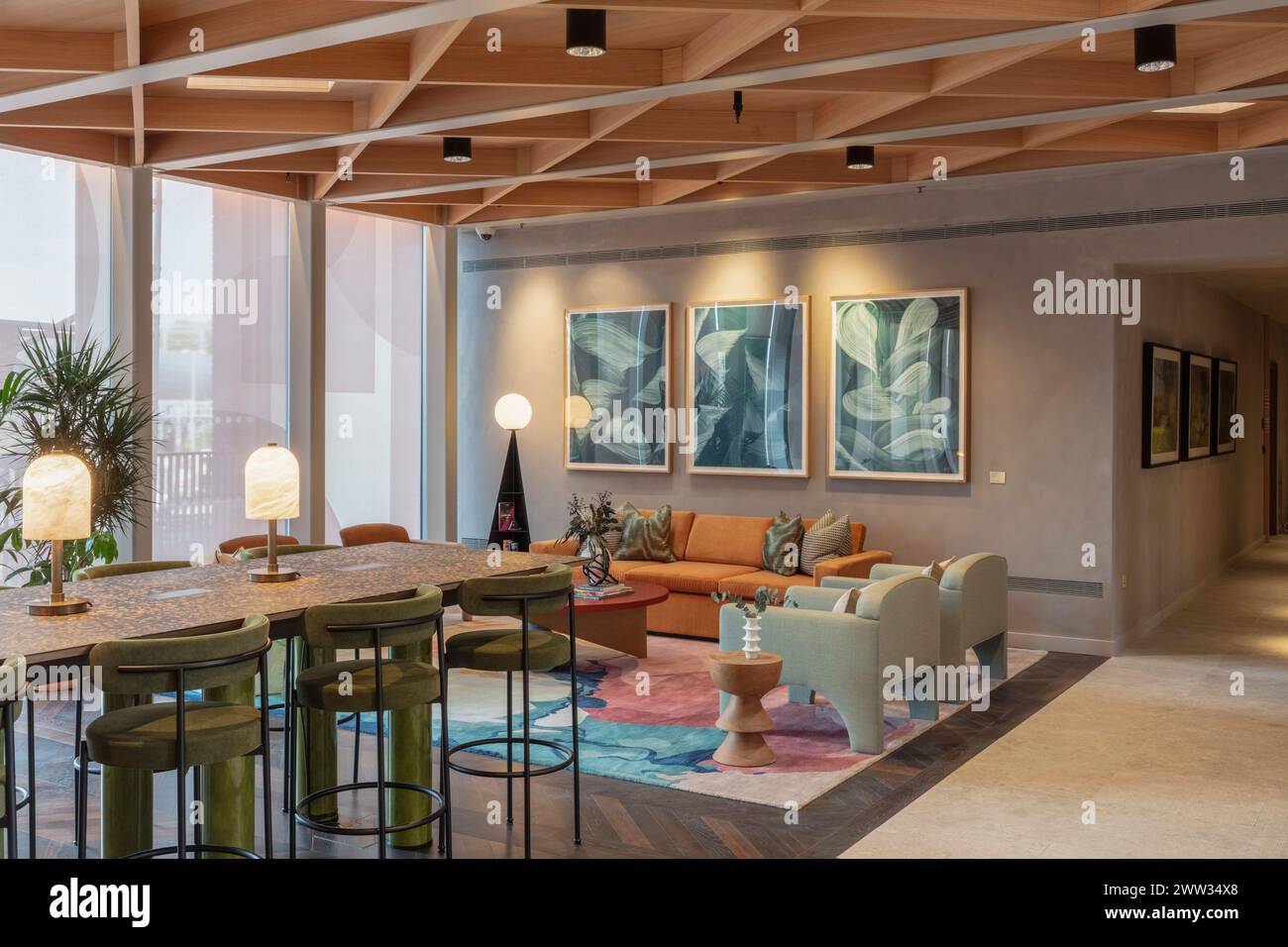 Communal living space with nicely styled seating and art on display ...