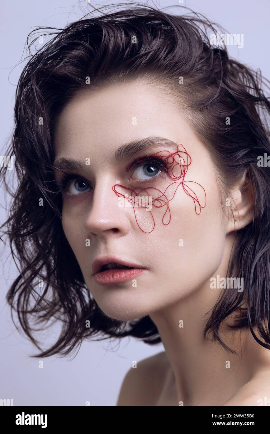 Portrait of beautiful young woman with deep blue eyes, red tangled ...