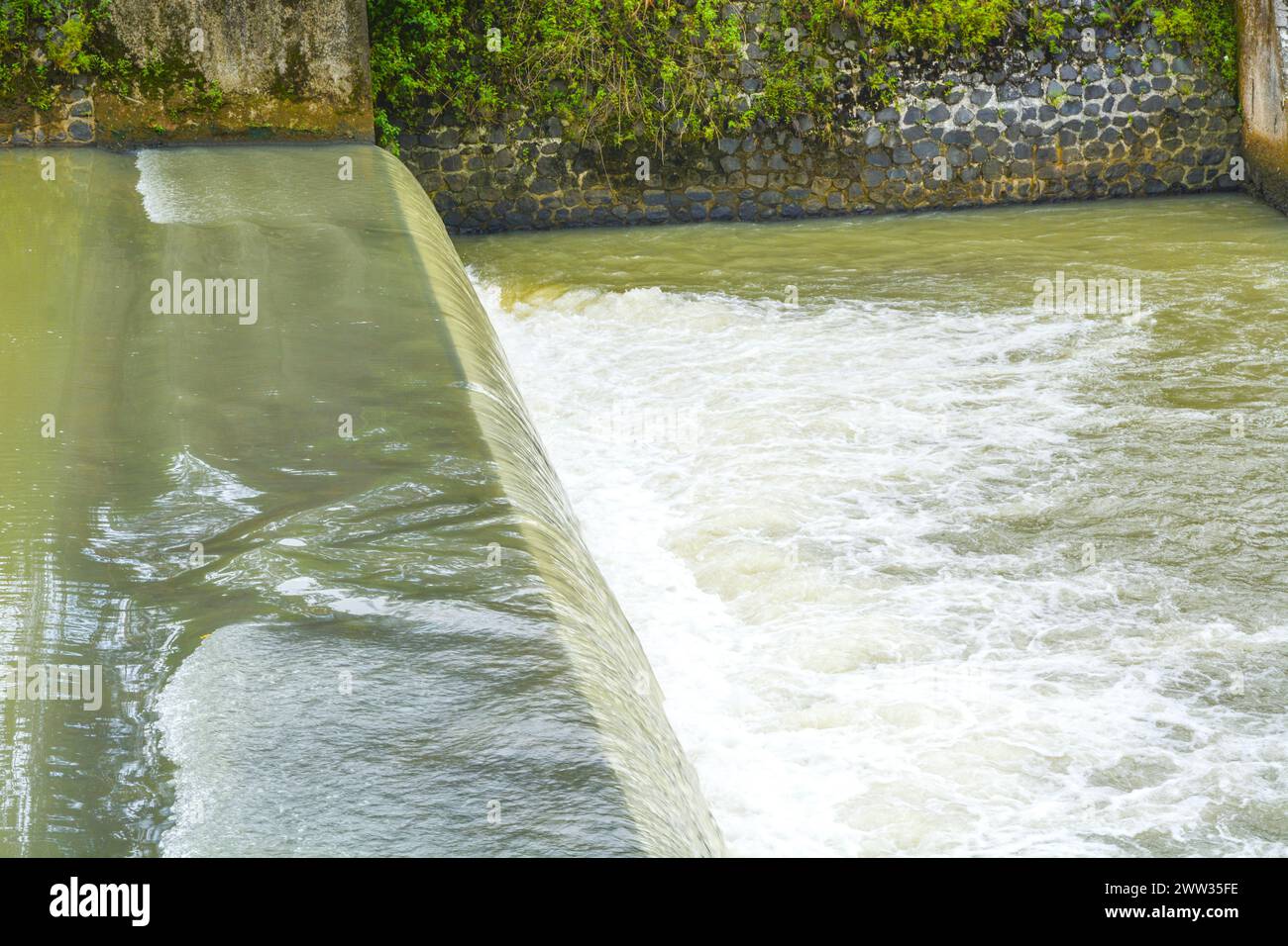 A fast-flowing stream and dramatic lenticular clouds against a dark sky ...