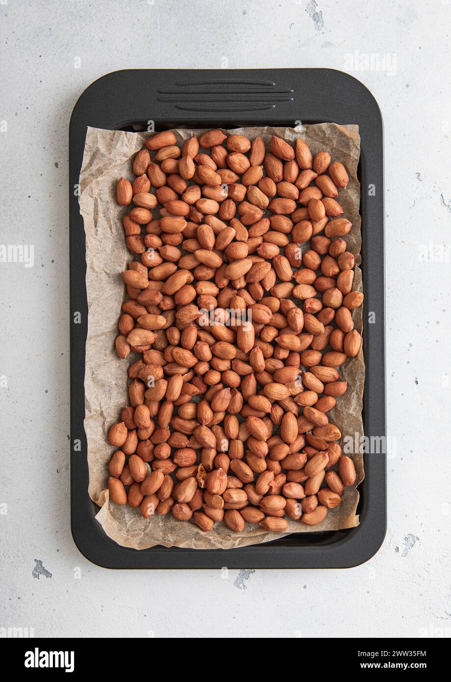 Baking tray with raw healthy red peanut nuts on light kitchen ...