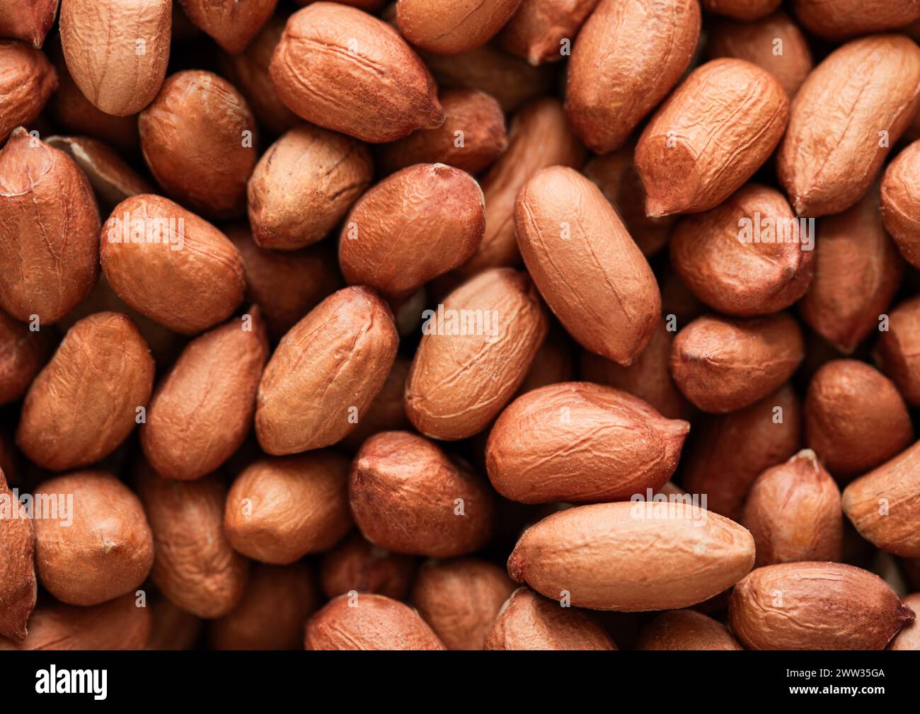 Raw peeled red peanut nuts top view macro background Stock Photo - Alamy