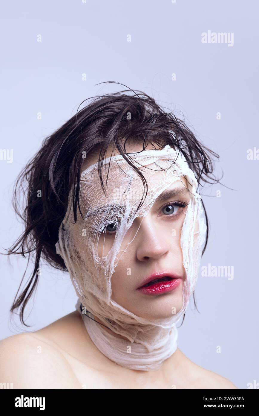 Young woman with bandage on face after facial plastic surgery. Changes ...
