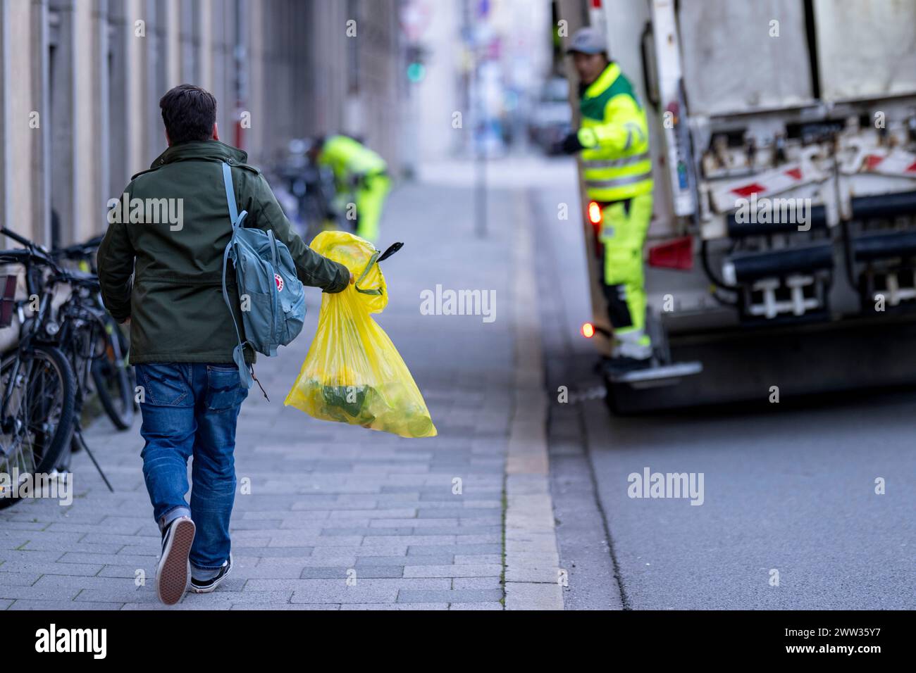Munich, Germany. 21st Mar, 2024. A resident runs after a garbage truck ...