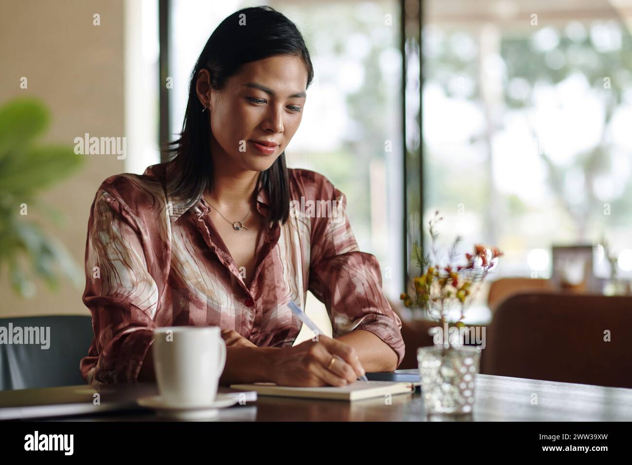 Portrait of inspired woman writing business plan when having morning ...