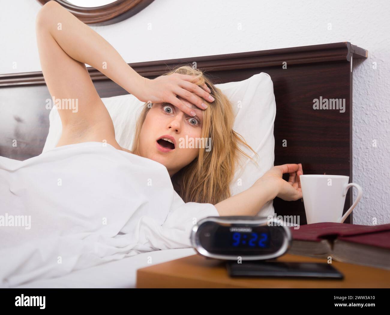 Woman in panic looks at clock Stock Photo - Alamy