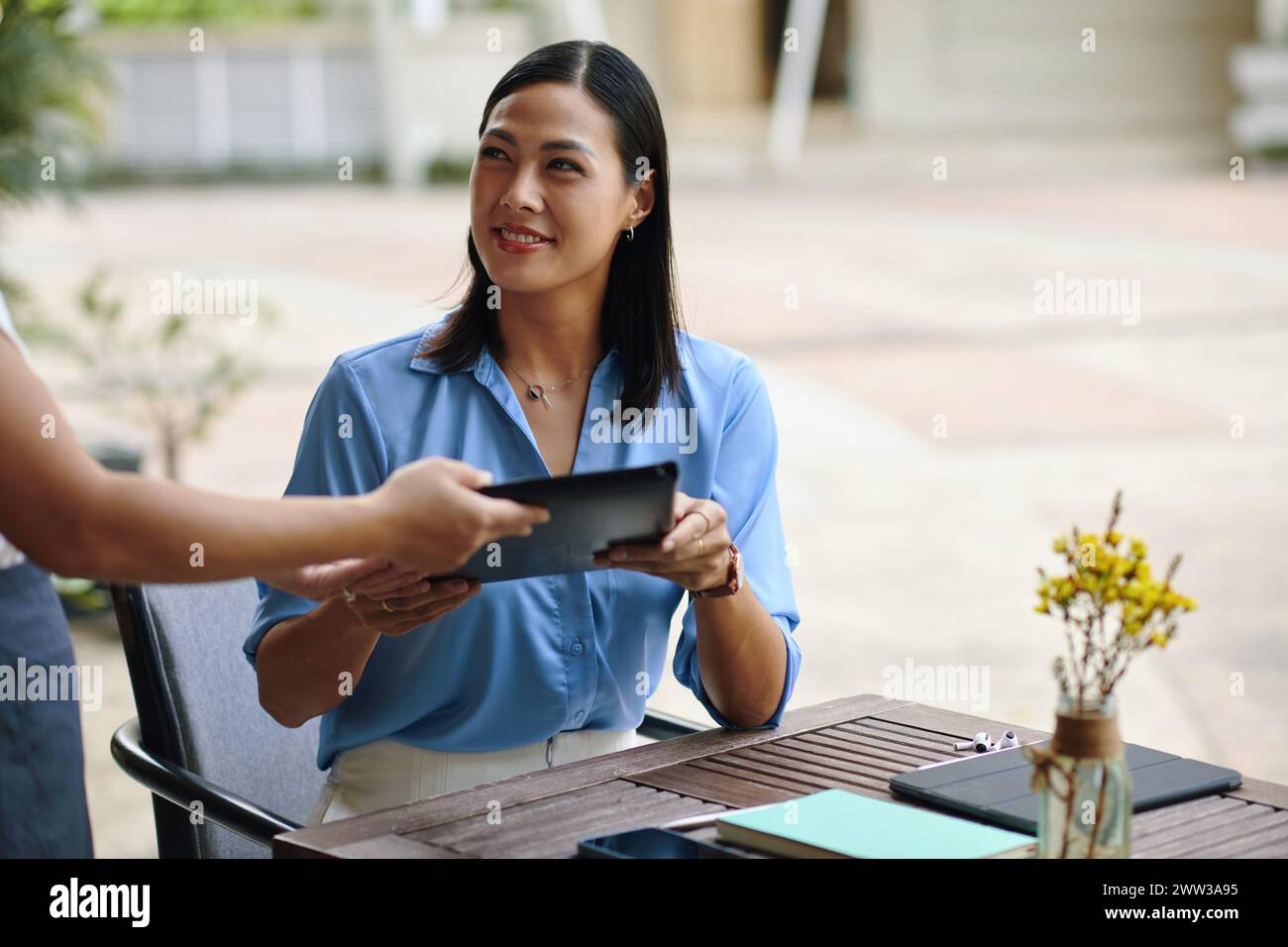 Waiter giving menu to cafe guest Stock Photo - Alamy