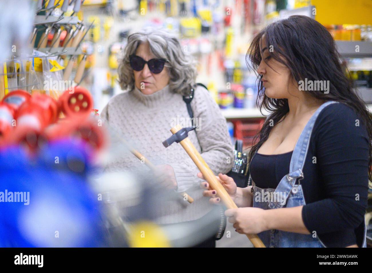 Two women engaged in conversation while shopping for tools in a ...
