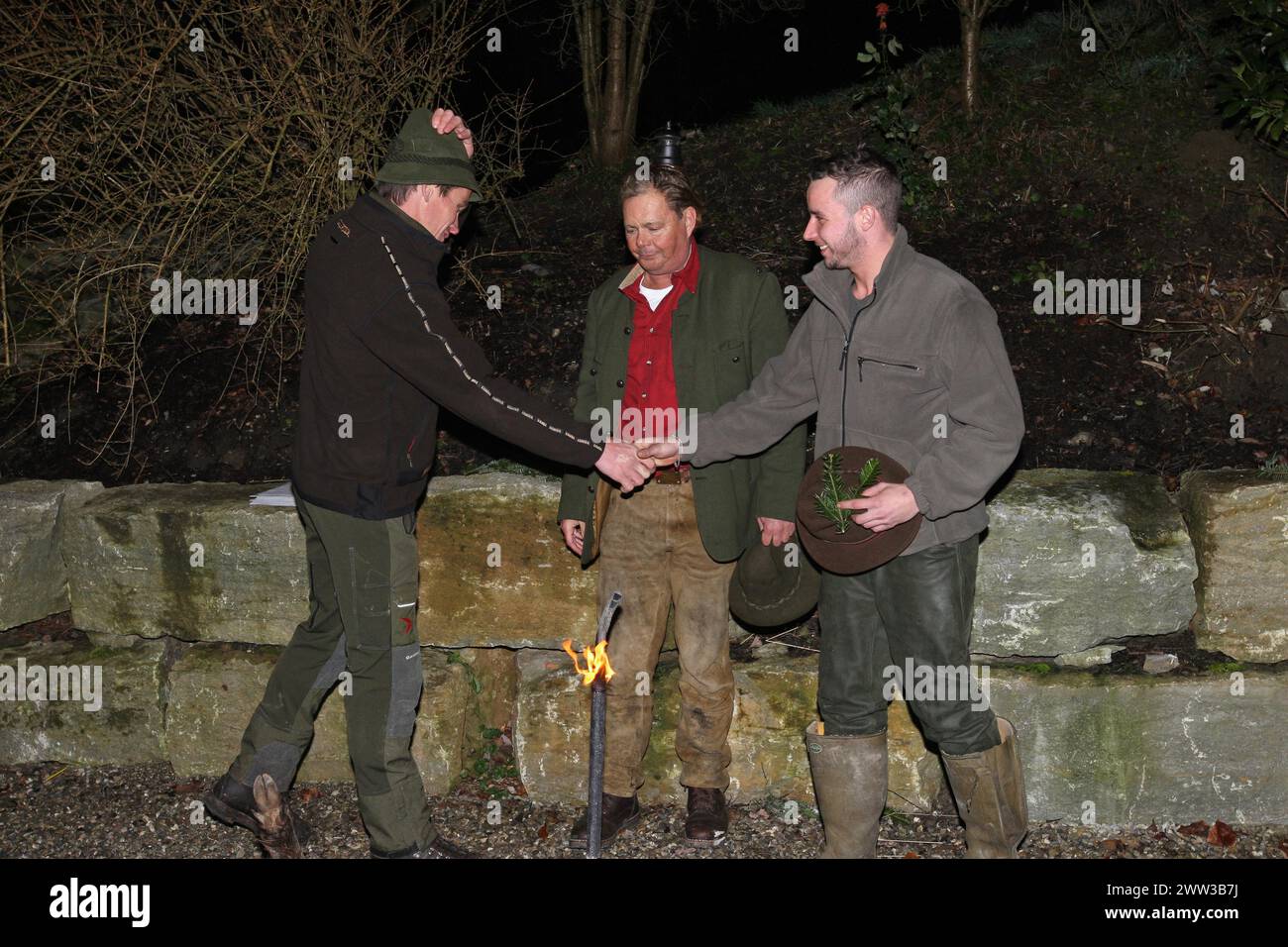 Wild boar (Sus scrofa) Hunting guide presents hunter with a gun after ...