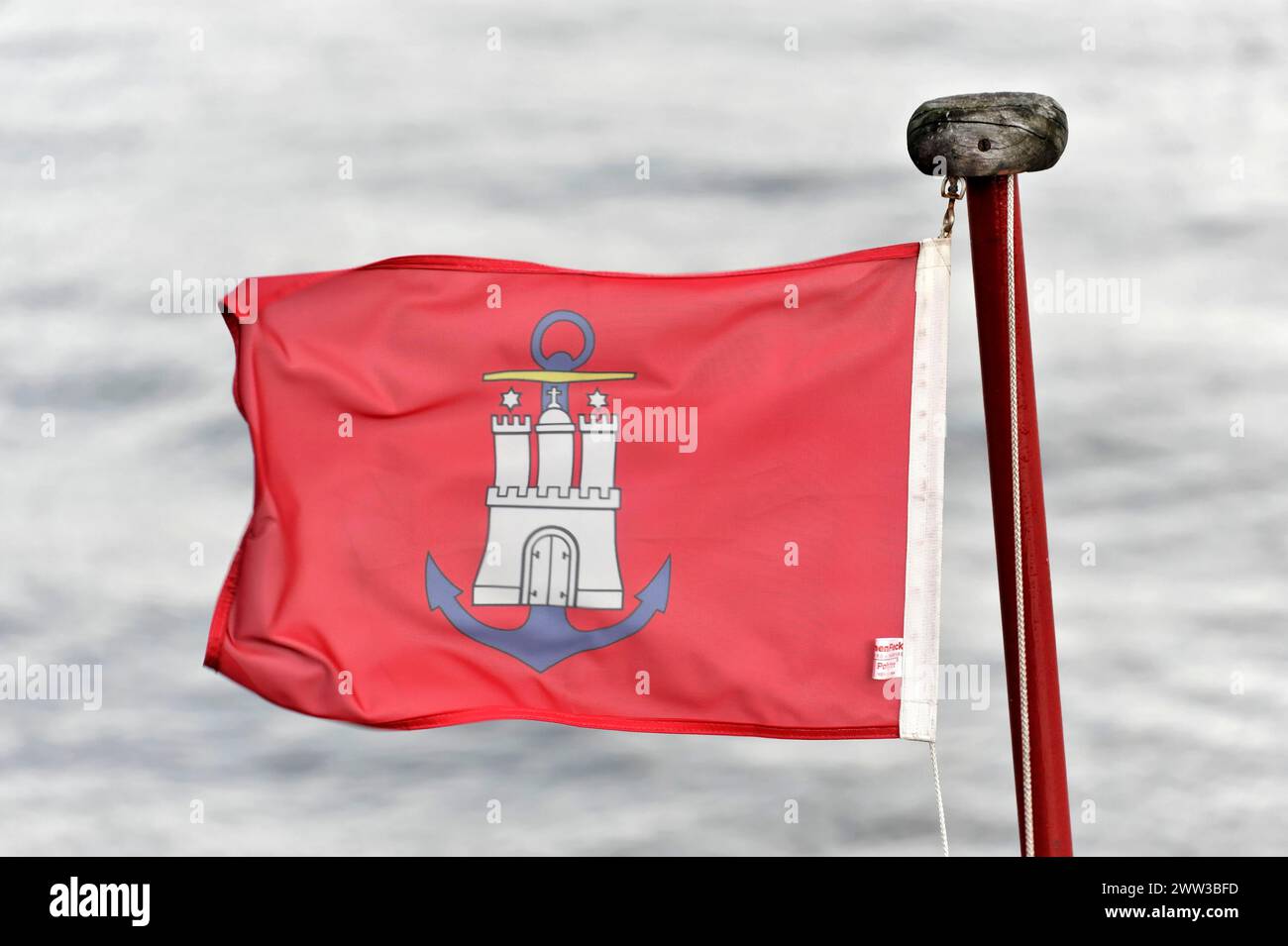 Red flag with the coat of arms of Hamburg waving in the wind, attached ...