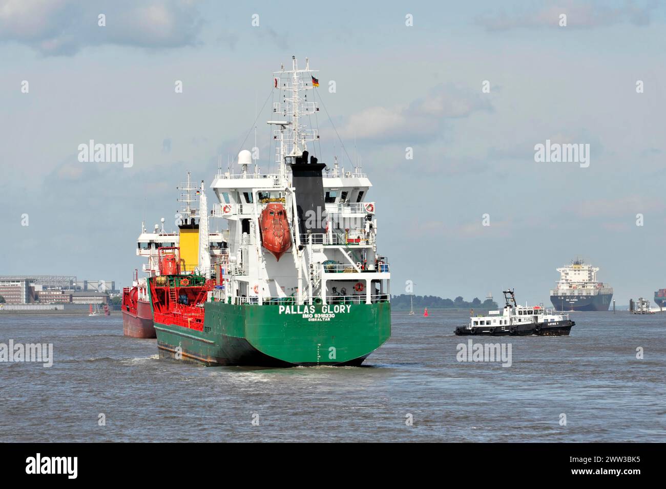 Large green container ship sailing supported by a tugboat in the ...