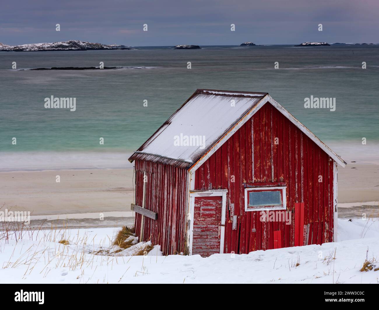 Red rorbuer fisherman's hut on the beach in the snow, Ramberg ...