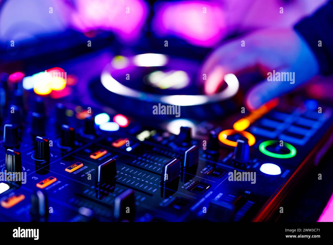 Hand of a DJ on a mixing desk, also called DJ controller or DJ console ...