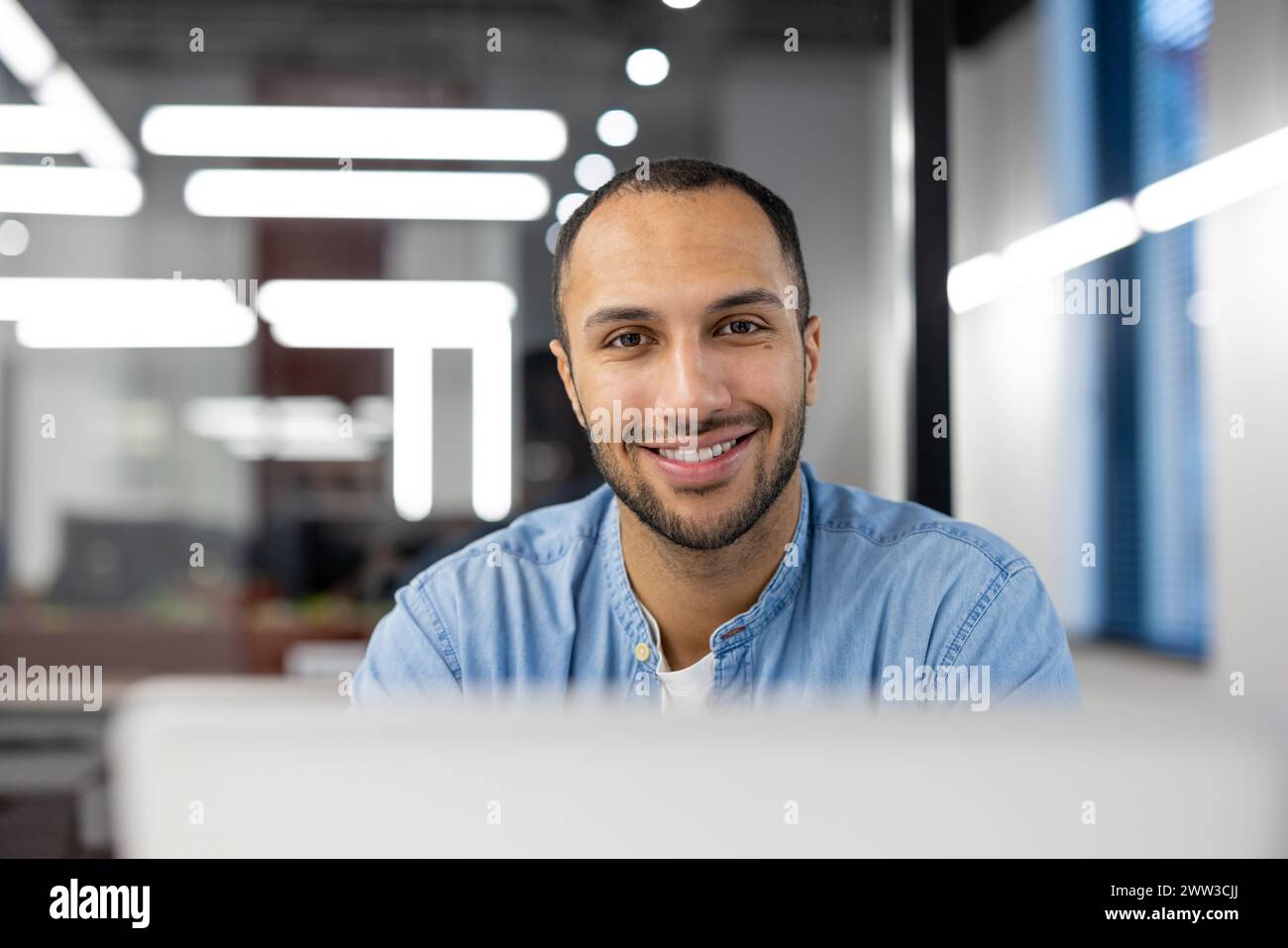 Focused professional working on a computer in a brightly lit modern ...