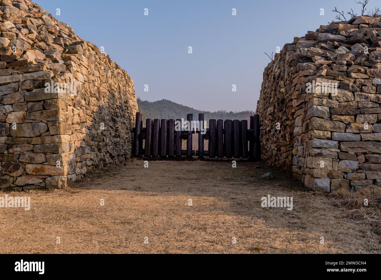 Wooden log blockade at gate of mountain fortress made of flat stones in ...
