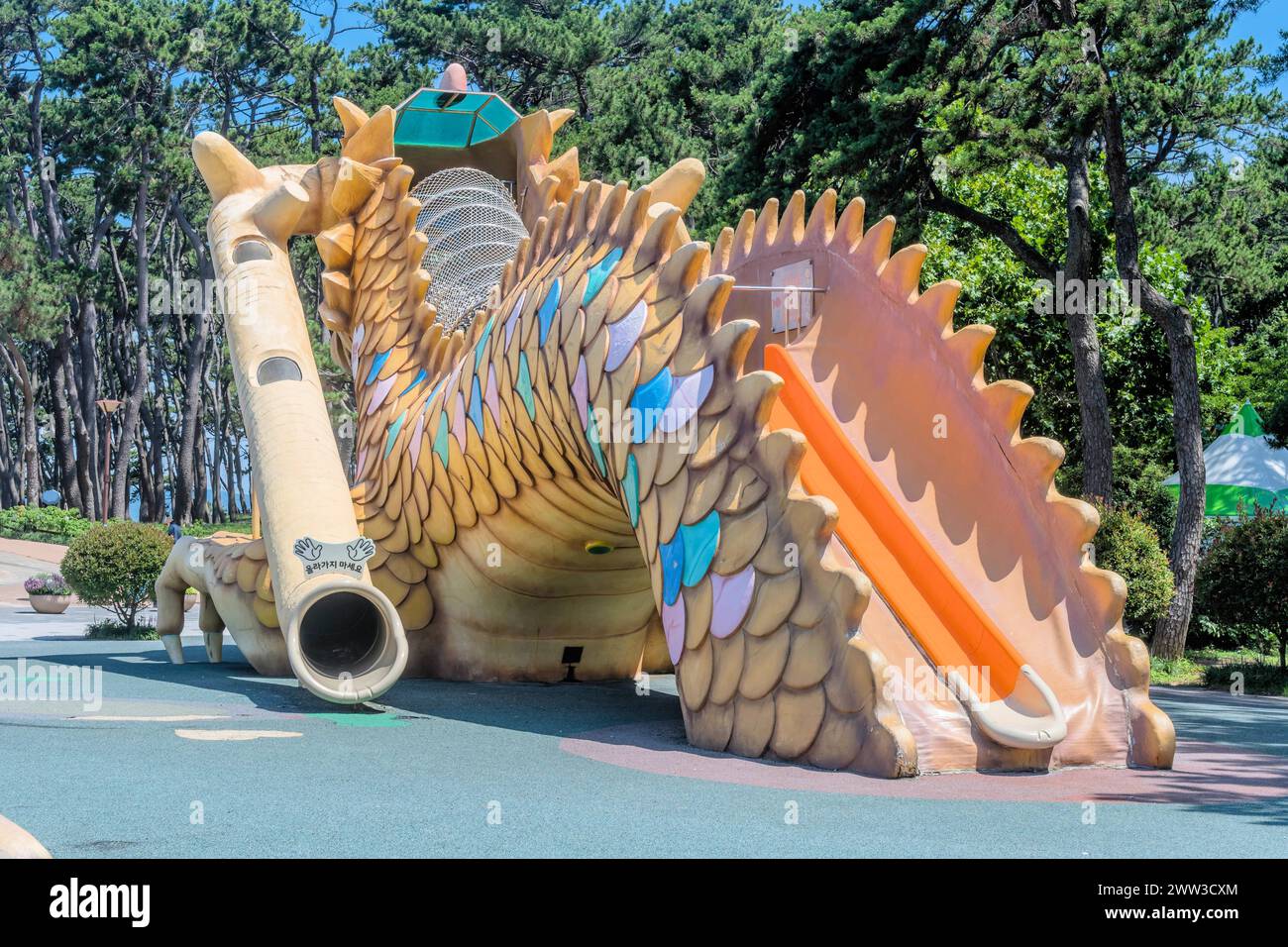 A large dragon-shaped play structure with slides in an outdoor ...
