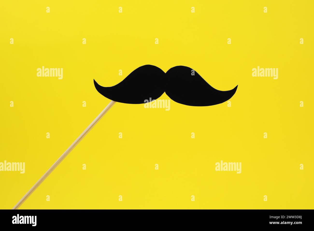 Fake paper mustache on stick against yellow background Stock Photo - Alamy