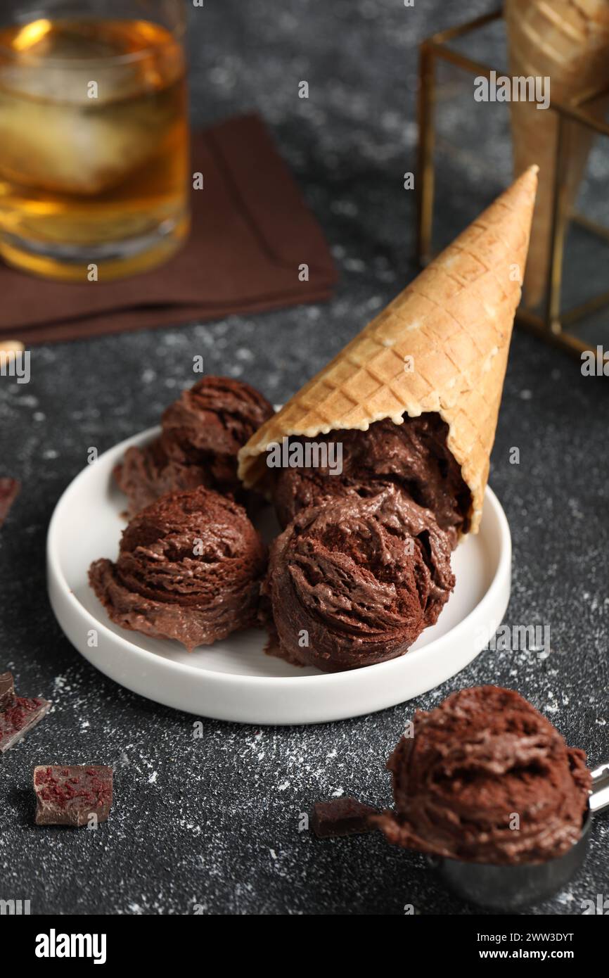 Tasty ice cream scoops, chocolate crumbs and waffle cones on dark ...