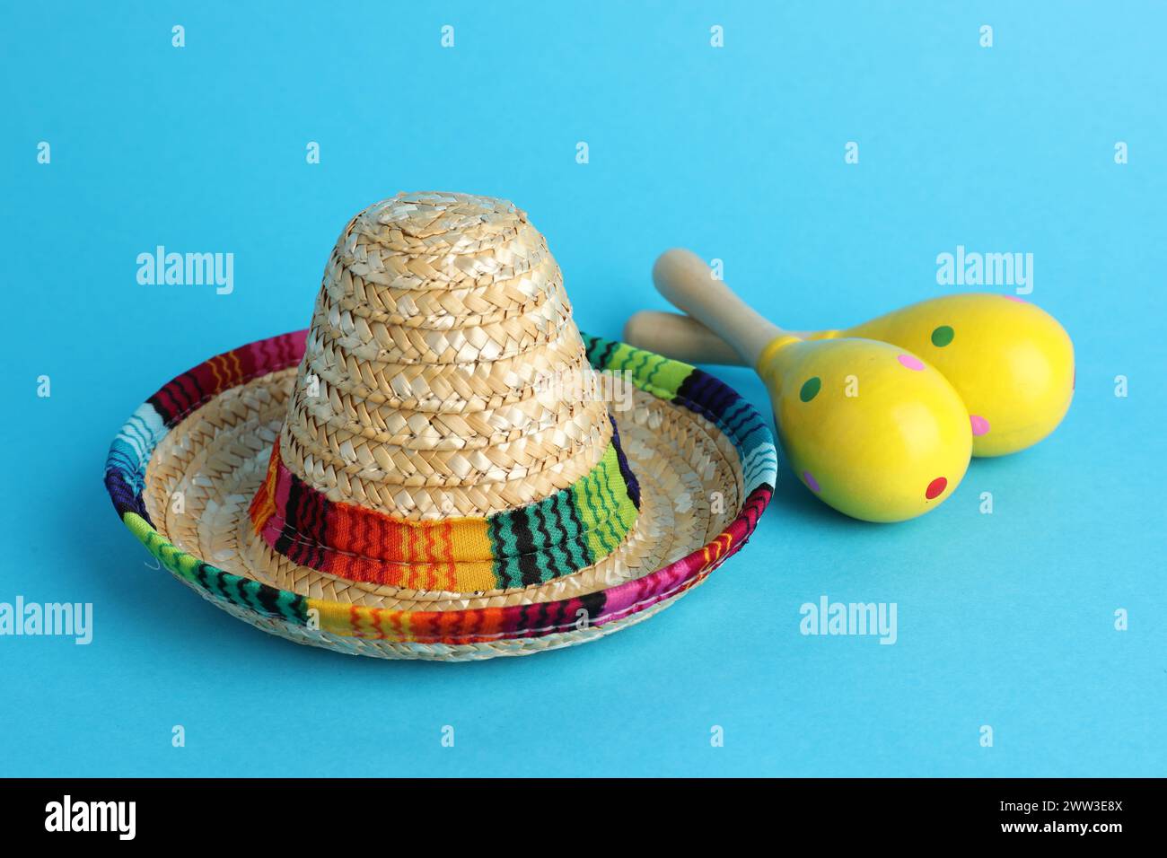 Mexican sombrero hat and maracas on light blue background Stock Photo ...
