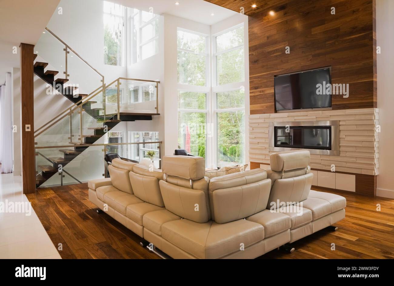 Living room with creamy beige colored L-shaped leather sofa and gas ...