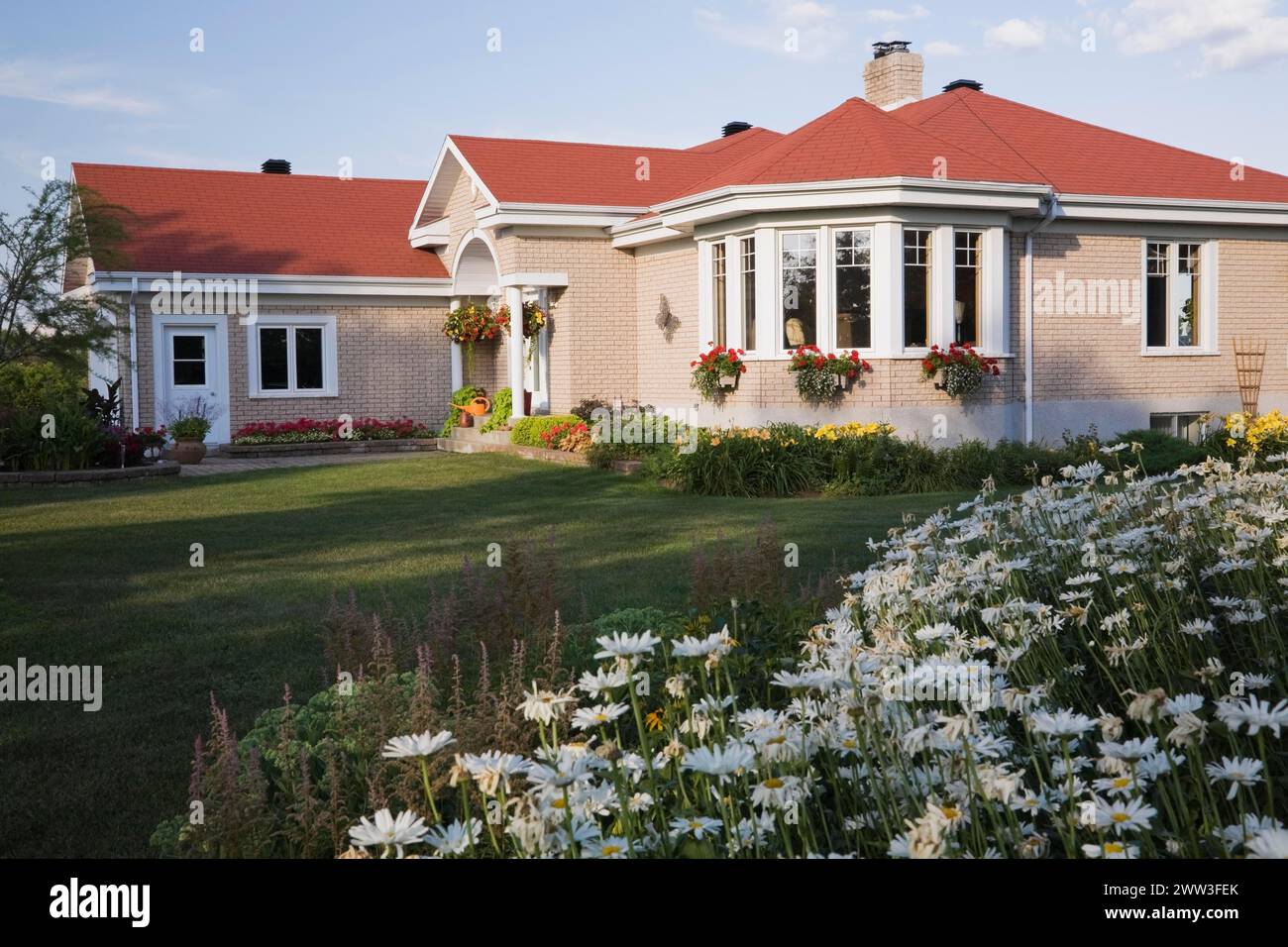 Tan brick with white trim home and landscaped front yard with white ...
