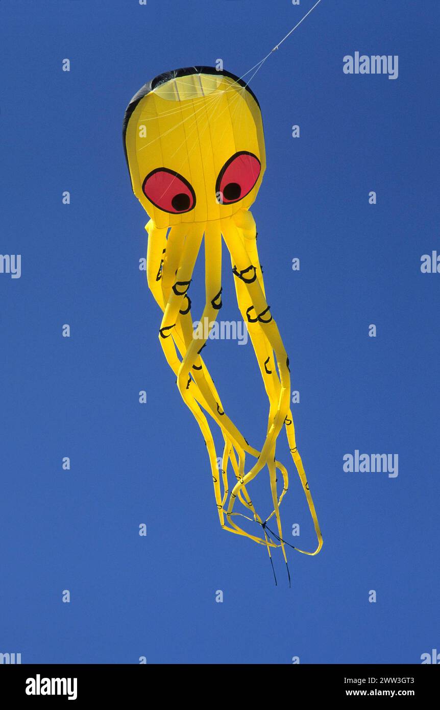 Yellow Kite in shape of an octopus with red eyes in the air Stock Photo ...