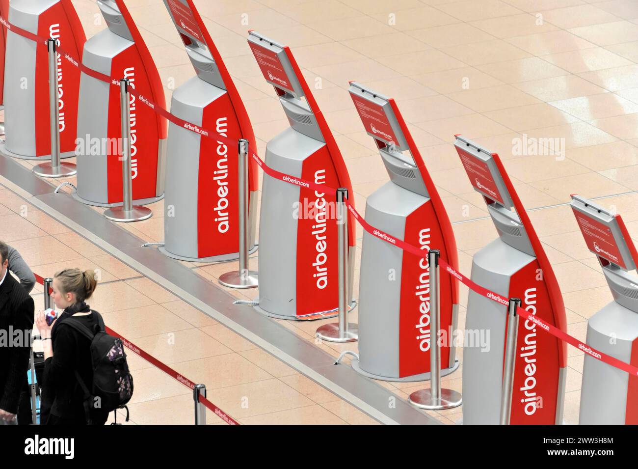 Travellers waiting at a row of self-service check-in machines at the ...