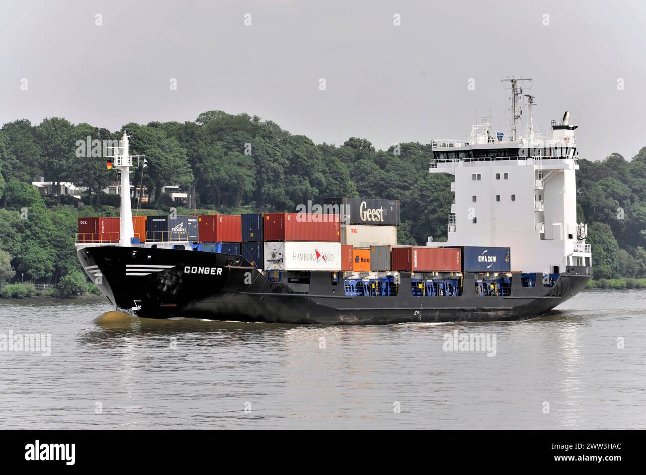 Conger, container ship on a river with visible cargo and cloudy sky ...