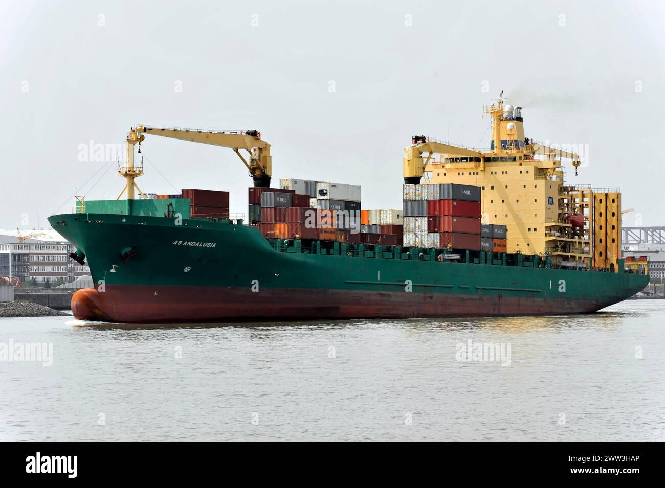 Green cargo ship loaded with containers in the harbour on a cloudy day, Hamburg, Hanseatic City ...
