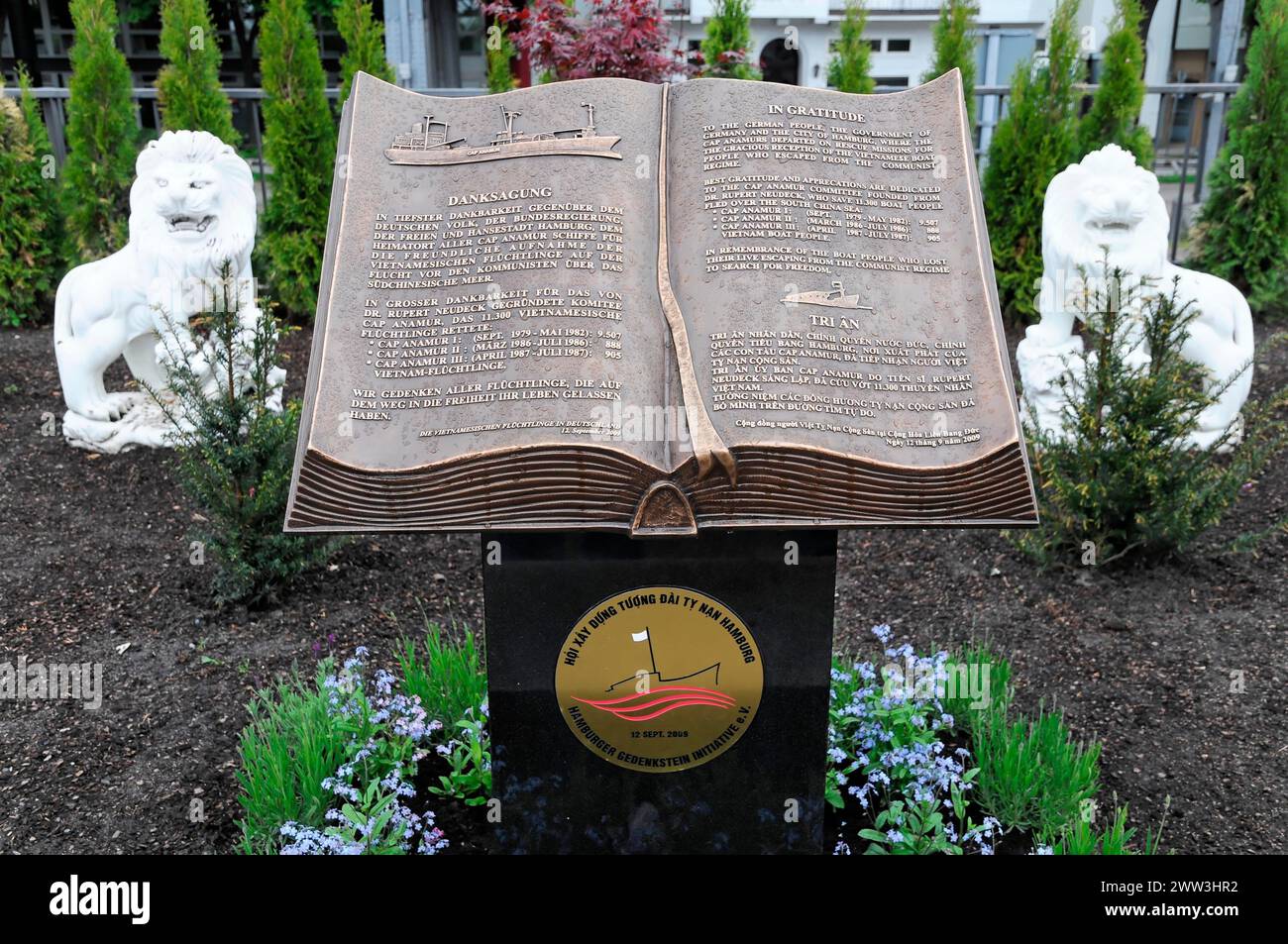 Garden statue of an open book with lion figures and a memorial emblem ...