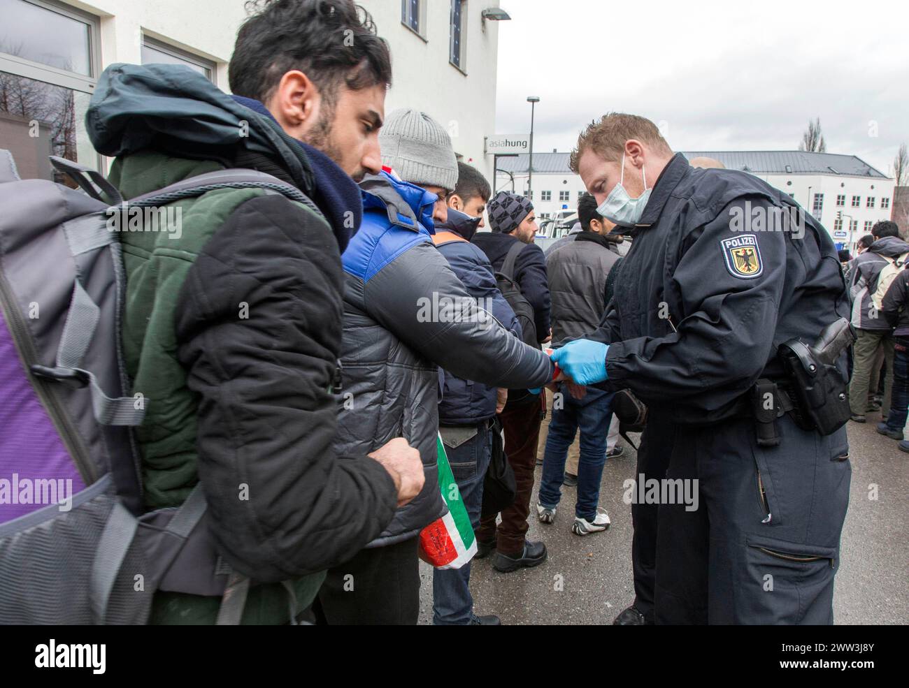After arriving at Rosenheim station, refugees are given wristbands by ...