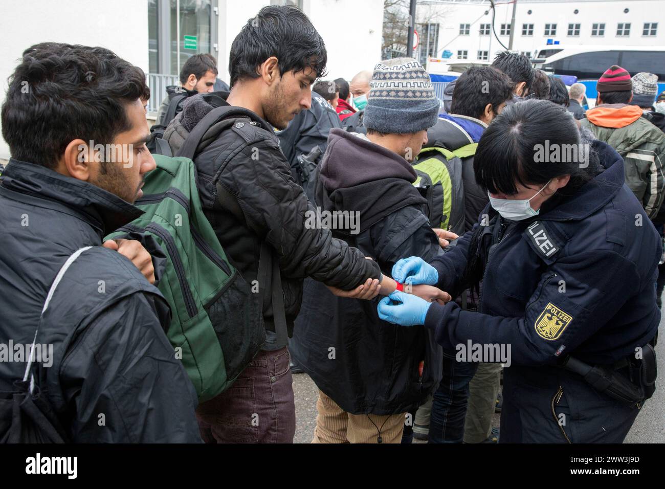 After arriving at Rosenheim station, refugees are given wristbands by ...
