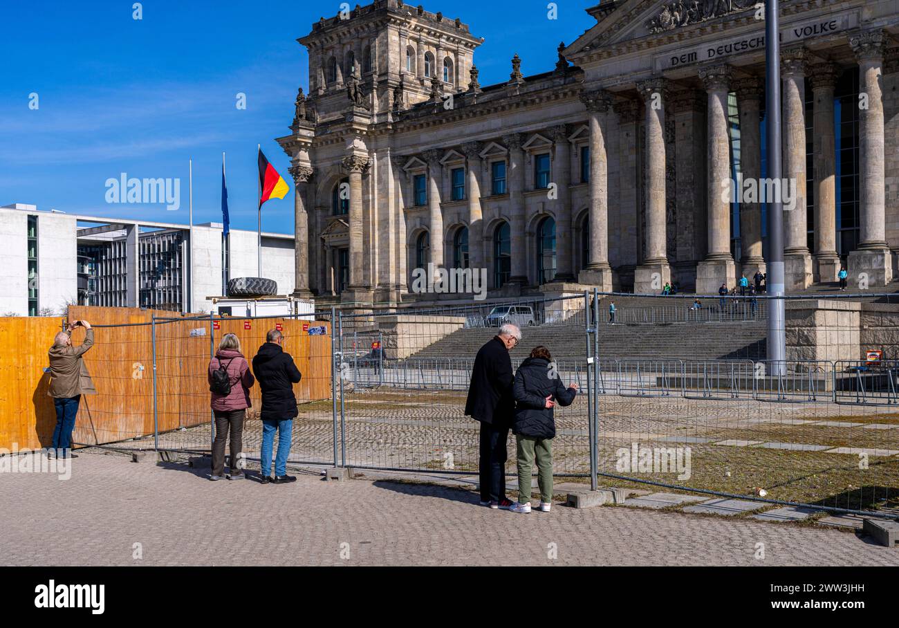 Tourists standing at the construction fence in front of the Reichstag building, Berlin, Germany ...