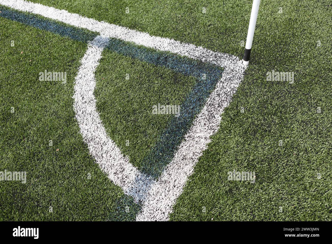 Corner quadrant markings on a 4G football pitch with base of corner flag - white lines, blue ...