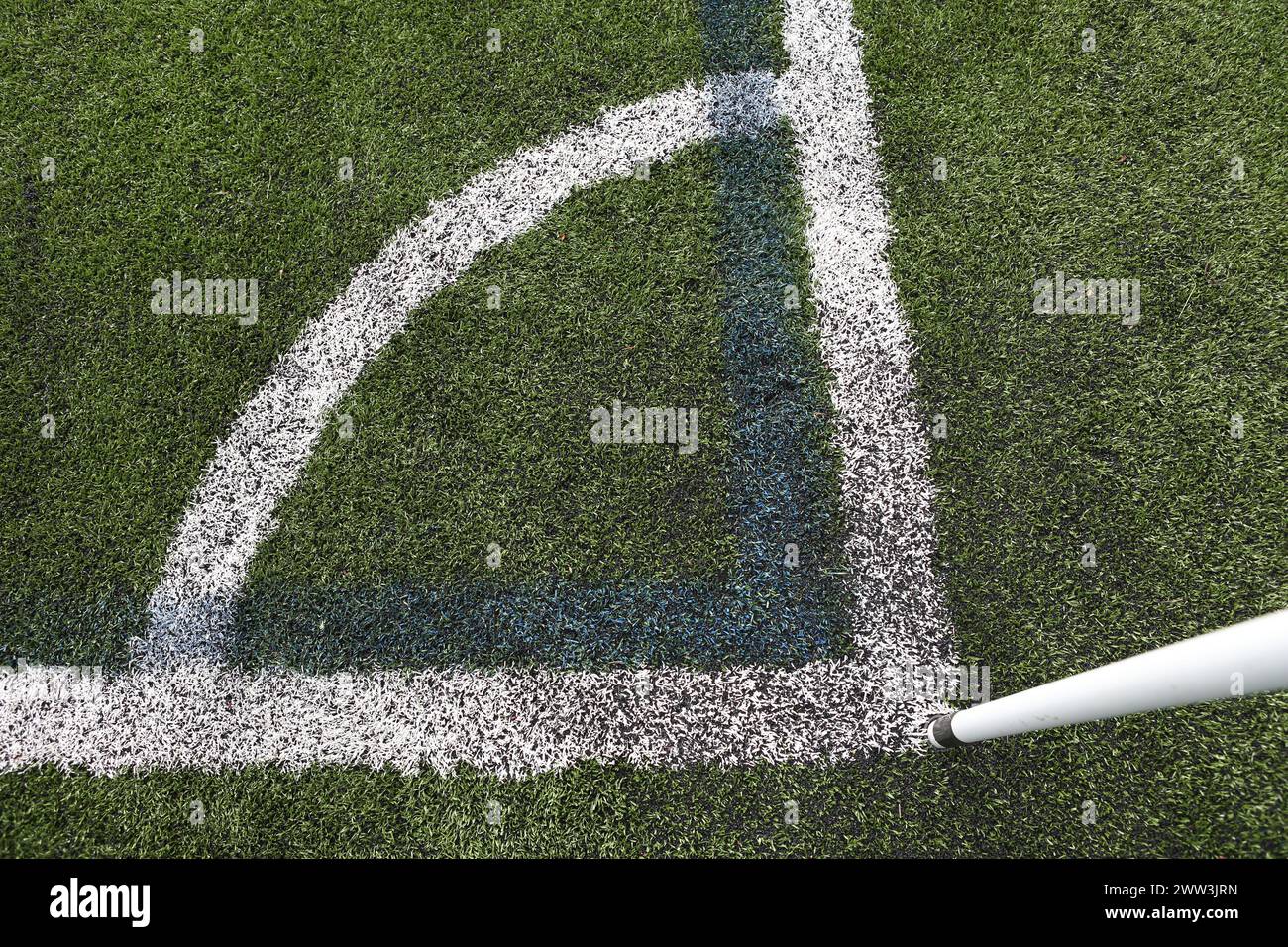 Corner quadrant markings on a 4G football pitch with base of corner flag - white lines, blue ...