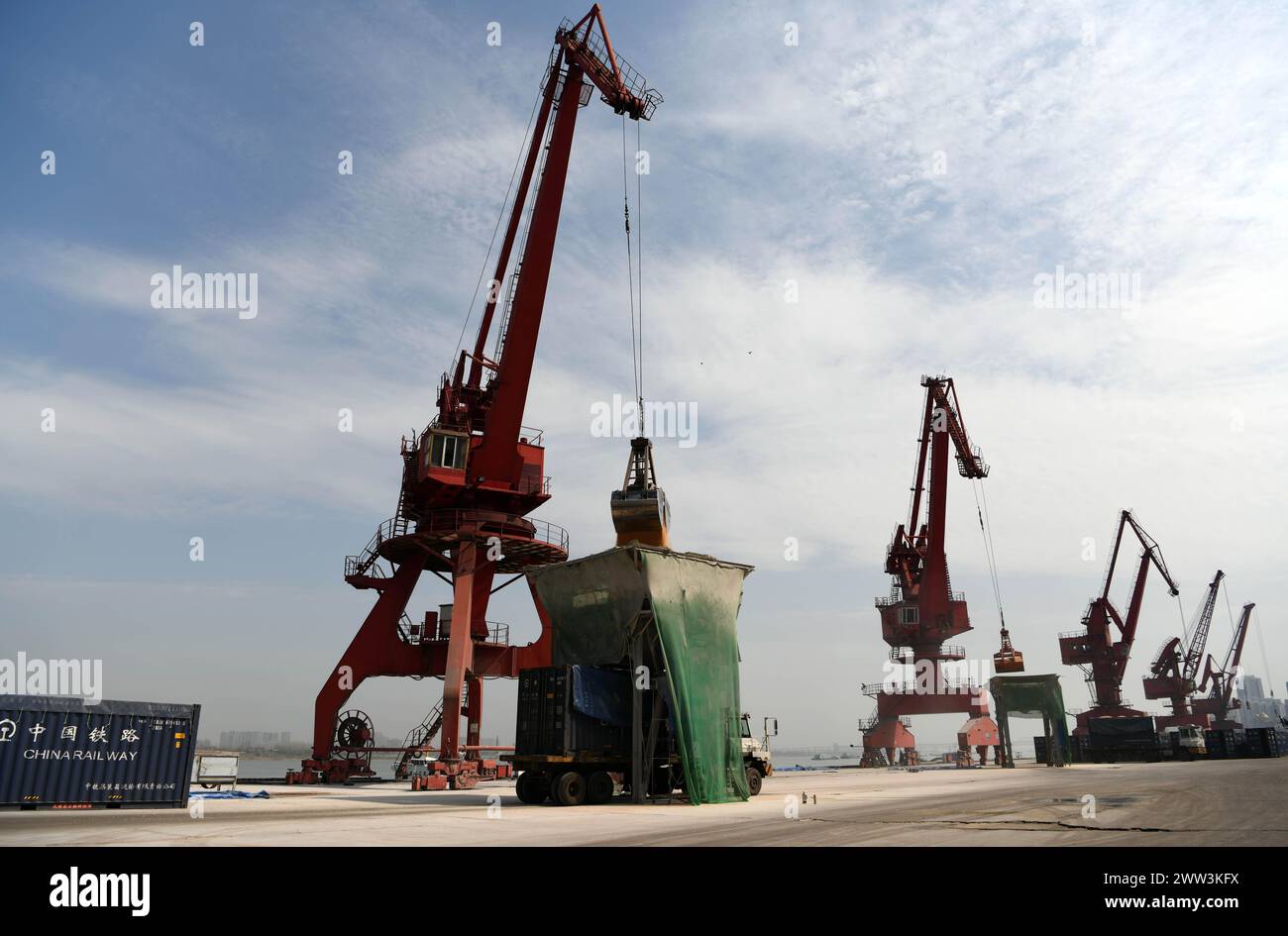 JIUJIANG, CHINA - MARCH 21, 2024 - A crane lifts corn from a ship into ...