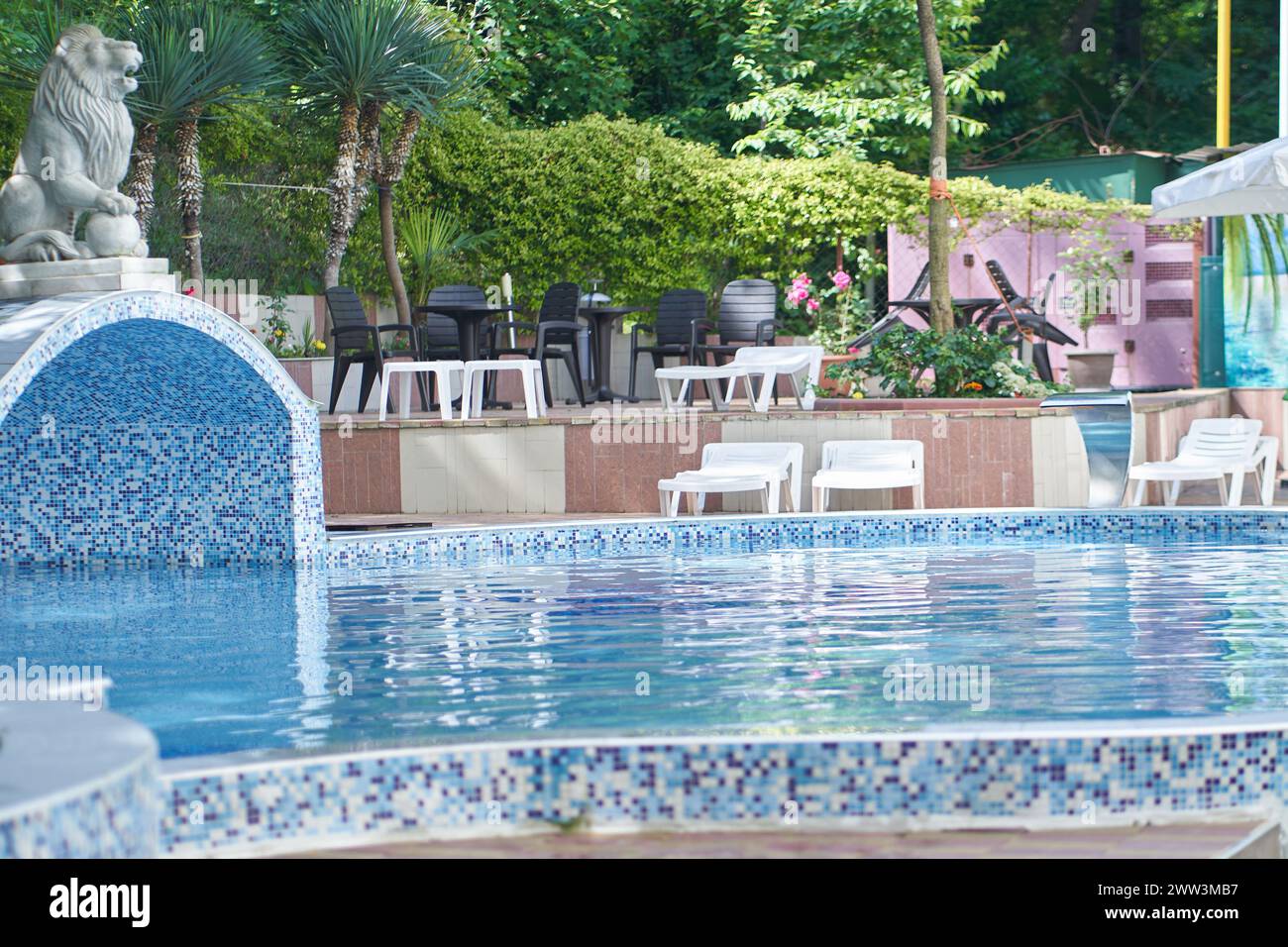 View of the hotel with swimming pool with mosaic tiles, sun loungers ...