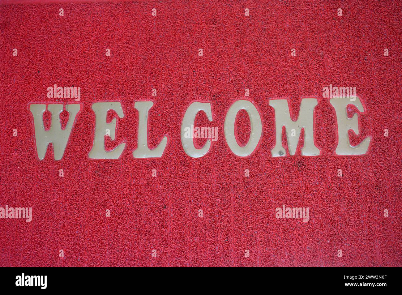Welcome letter on the red doormat Stock Photo - Alamy